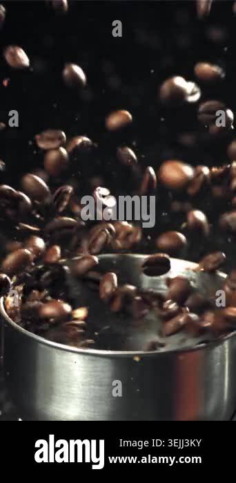 Coffee beans in a working grinder. Filmed on a high-speed camera at ...