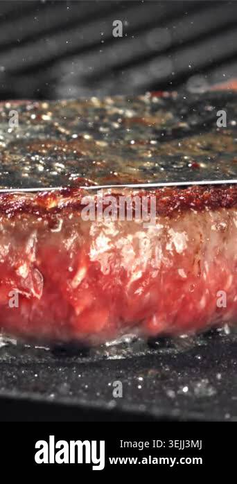 A burger made from natural meat is fried in a frying pan. Filmed on a ...