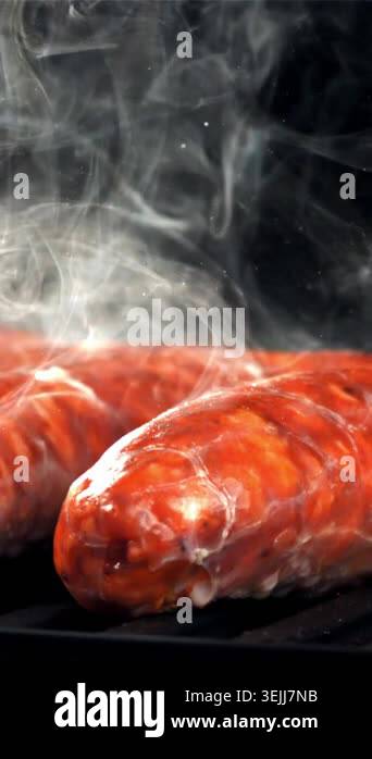 Sausages are fried with splashes in a pan. Filmed on a high-speed ...