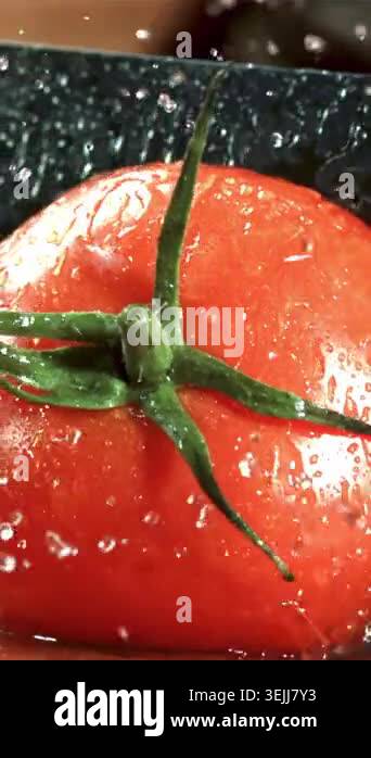 The knife cuts the tomato in half. Filmed on a high-speed camera at ...
