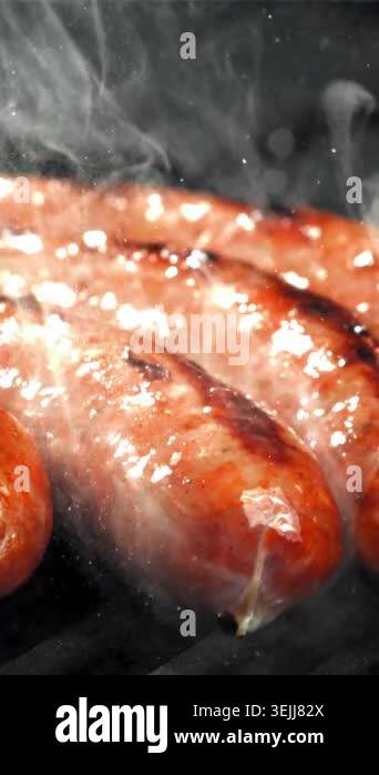 Sausages are fried with splashes in a pan. Filmed on a high-speed ...