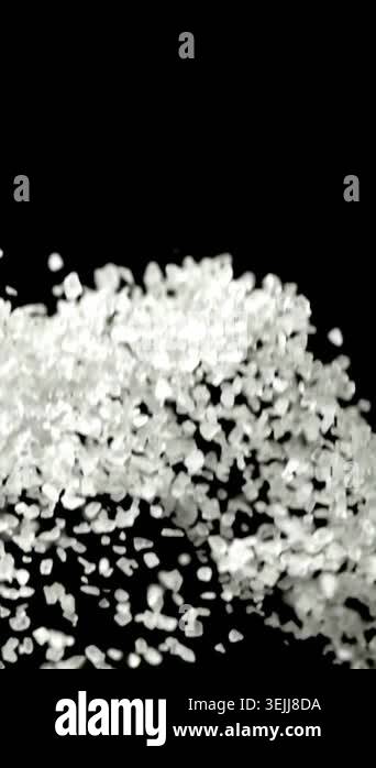 Salt flies up on a black background. Filmed on a high-speed camera at ...