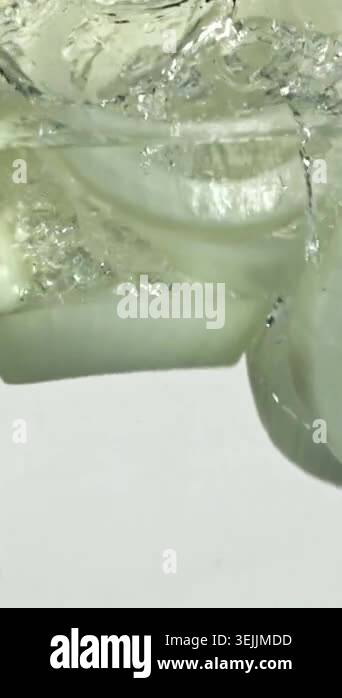 Onion rings falling under water on a white background. Filmed on a high ...