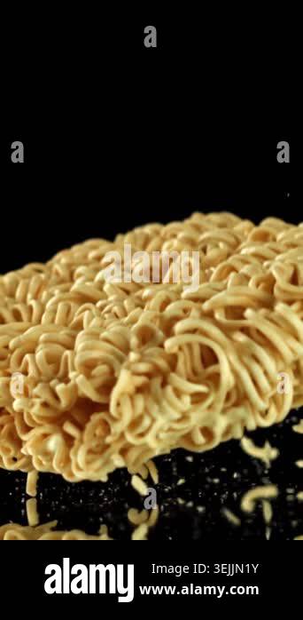 Dry instant noodles falling on a black background. Filmed on a high ...