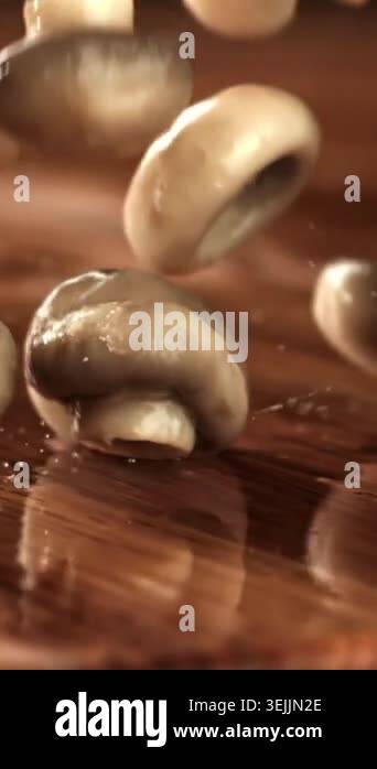 Pickled mushrooms fall on a cutting board. Filmed on a high-speed ...