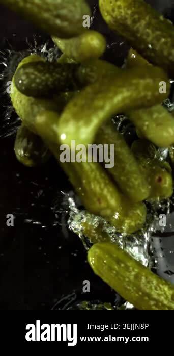 Pickled cucumbers fall into the water. Filmed on a high-speed camera at ...