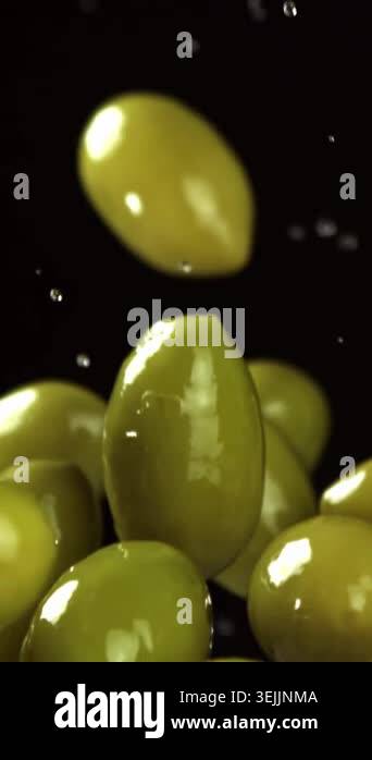 Olives flying on a black background. Filmed on a high-speed camera at ...