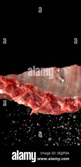 Raw ribs rise and fall on a black background. Filmed on a high-speed ...