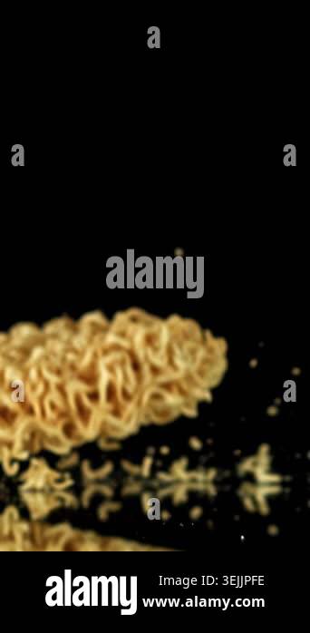 Dry instant noodles falling on a black background. Filmed on a high ...
