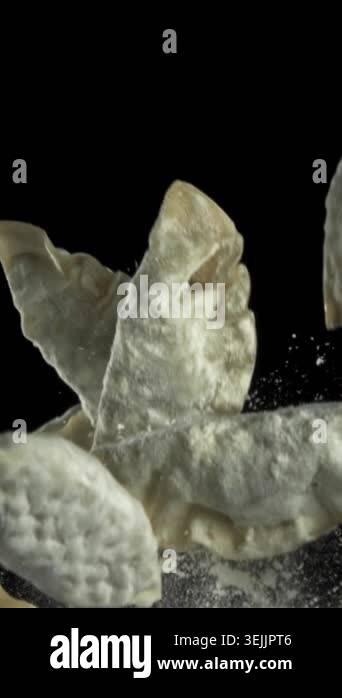 Asian gyoze dumplings fly up and fall down. Filmed on a high-speed ...