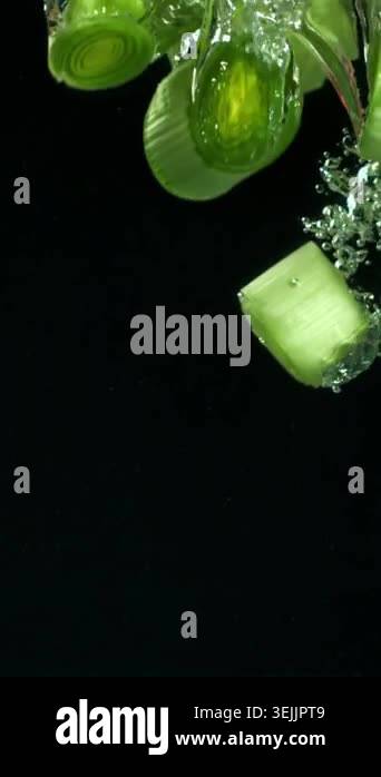 Sliced leeks fall under water. Filmed on a high-speed camera at 1000 ...