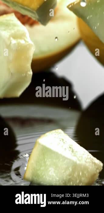 Pieces of melon fall on a wet surface. Filmed on a high-speed camera at ...