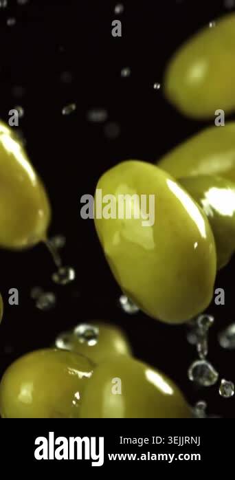 Olives flying on a black background. Filmed on a high-speed camera at ...