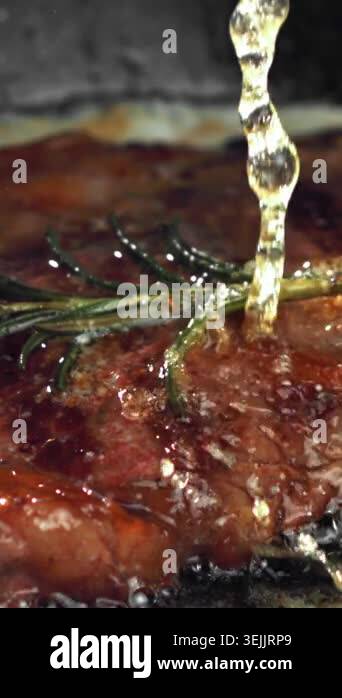 Beef steak in a pan with garlic and spices. Filmed on a high-speed ...