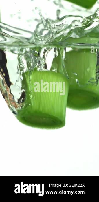 Sliced leeks fall under water. Filmed on a high-speed camera at 1000 ...