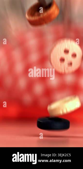 Multi-colored sewing buttons fall on the table. Filmed on a high-speed ...