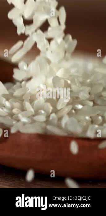Rice falls into a wooden spoon. Filmed on a high-speed camera at 1000 ...