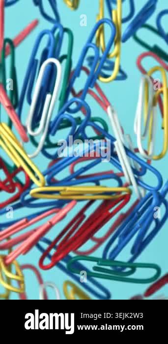 Multi-colored paper clips fly up and fall down. Filmed on a high-speed ...