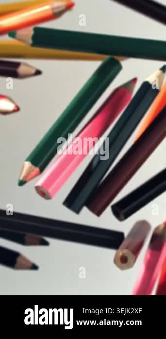 Multi-colored pencils fly up and fall on a white background. Filmed on ...