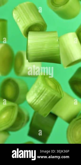 Sliced leeks flying on a green background. Filmed on a high-speed ...