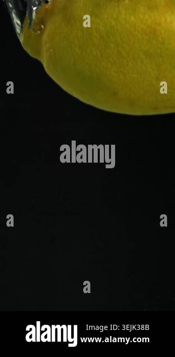 Lemons falling under water on a black background. Filmed on a high ...