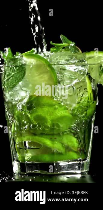 The mojito cocktail is poured into a glass. Filmed on a high-speed ...