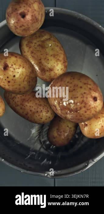 Potatoes fall into a pot of water. View from above. Filmed on a high ...
