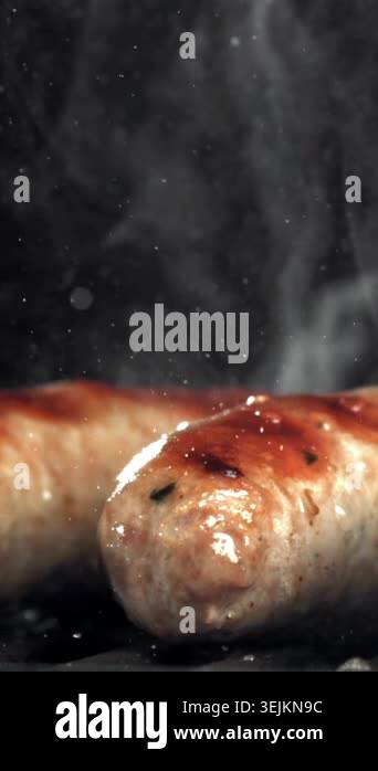 Sausages are fried in a pan with a splash of oil. Filmed on a high ...