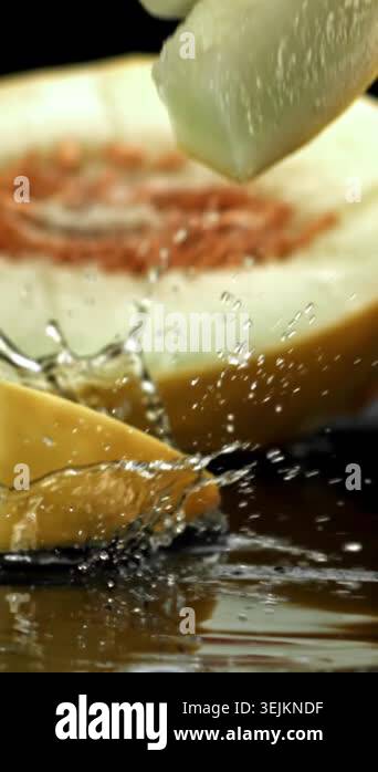 Pieces of melon fall on a wet surface. Filmed on a high-speed camera at ...