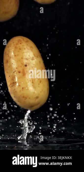 Fresh potatoes fall on the table. Filmed on a high-speed camera at 1000 ...