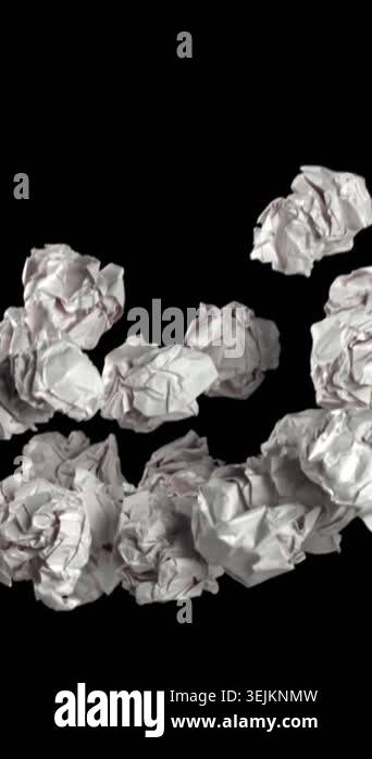Crumpled paper flies and falls on a black background. Filmed on a high ...