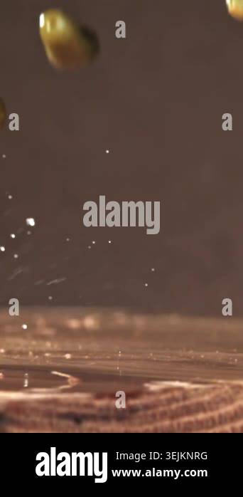 Pickled cucumbers fall on a wooden table. Filmed on a high-speed camera ...