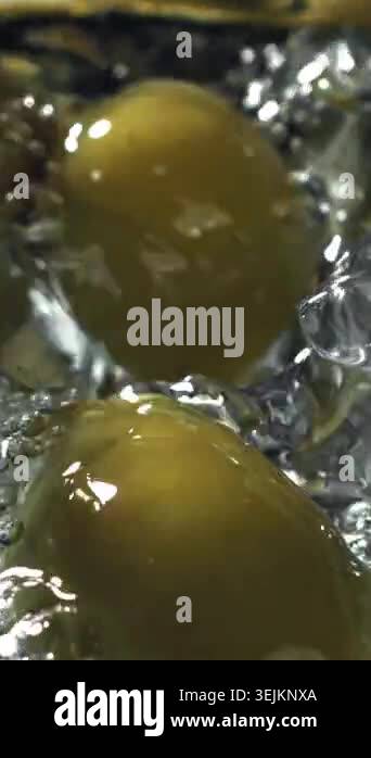 Martini is poured into a glass with ice and olives. Filmed on a high ...