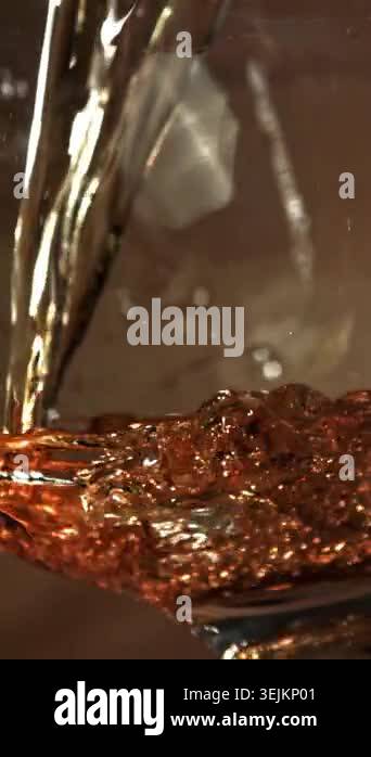 Cognac is poured into a glass. Filmed on a high-speed camera at 1000 ...