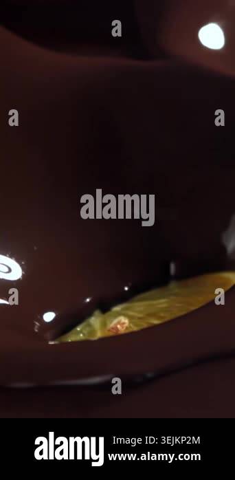 Lemon slices fall into the chocolate. Filmed on a high-speed camera at ...