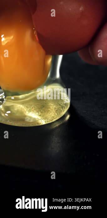 The broken egg falls into the pan. Filmed on a high-speed camera at ...