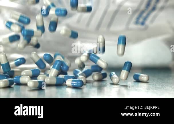 Blue white capsules scattered near blister pack on factory table Filmed ...