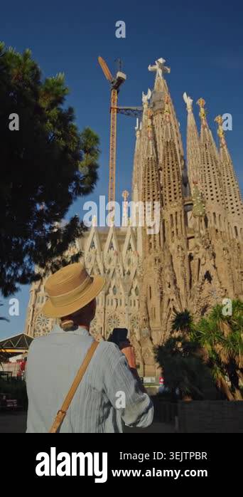 Female tourist preparing to photograph Sagrada Familia basilica with ...