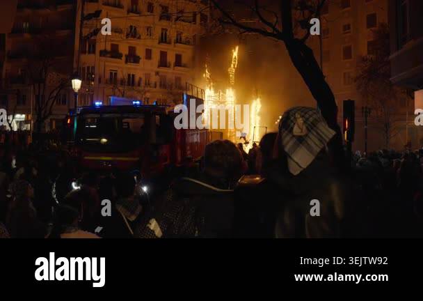 VALENCIA, SPAIN - MARCH 19, 2026: Large crowd watching a burning falla ...