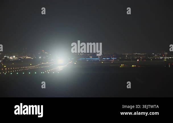 Wide view of airport at night showing illuminated runway edge light ...