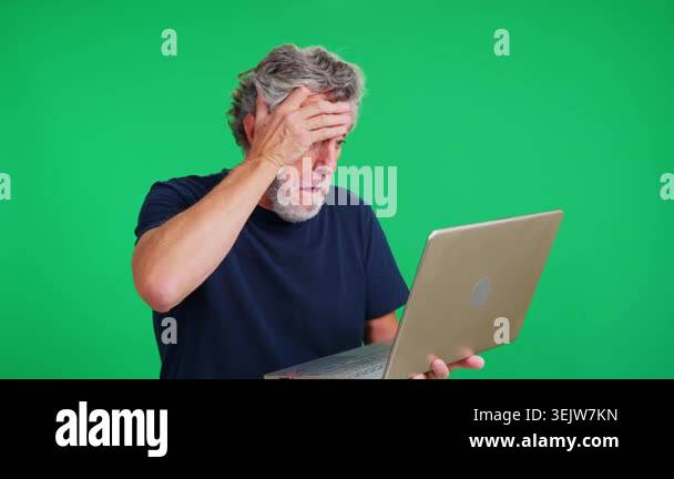 Man celebrating something while using a laptop on a green screen ...