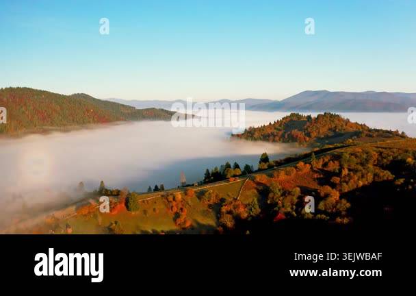 Thick layer of fog covering high mountains with terracotta and green ...