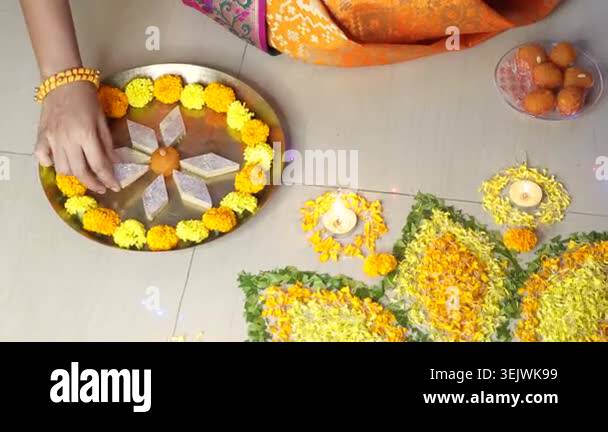 Happy Diwali.Indian woman preparing puja thali with flowers, rangoli ...