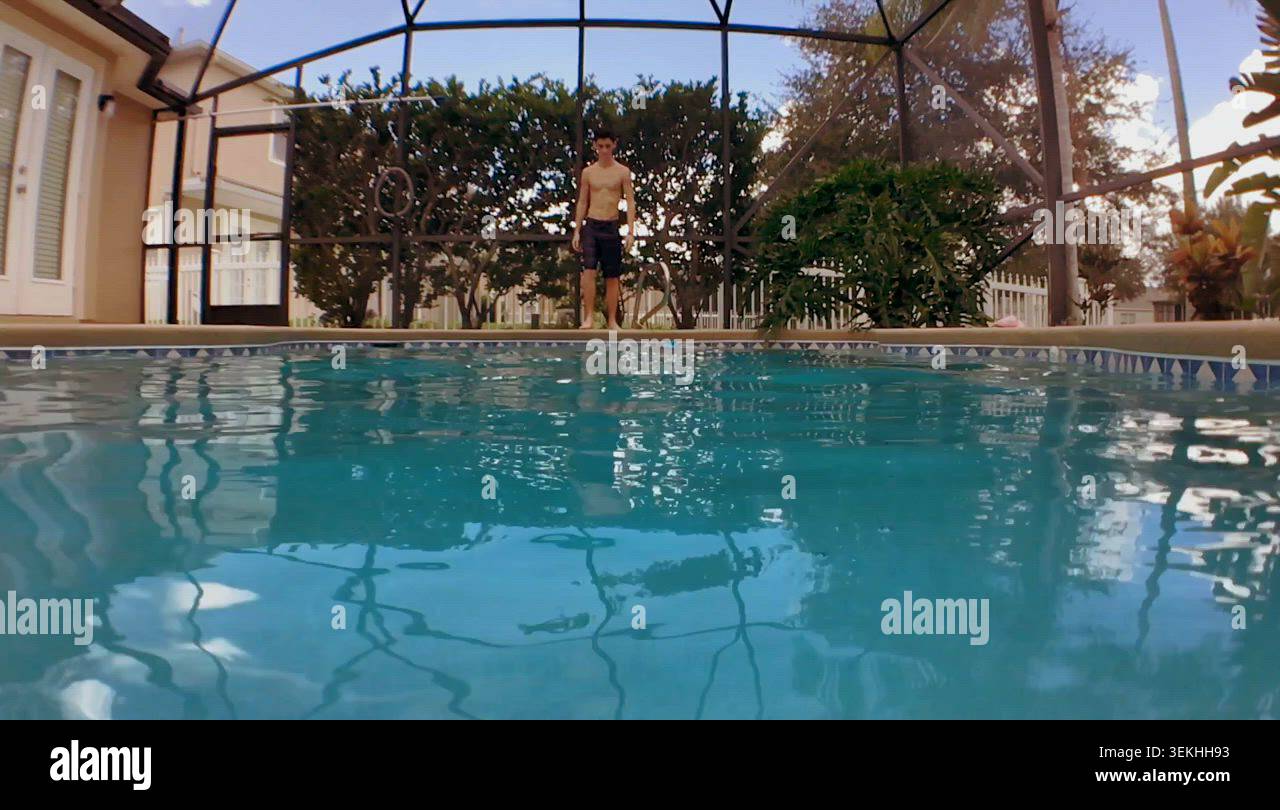 Teenager jumping into a swimming pool Stock Video Footage - Alamy