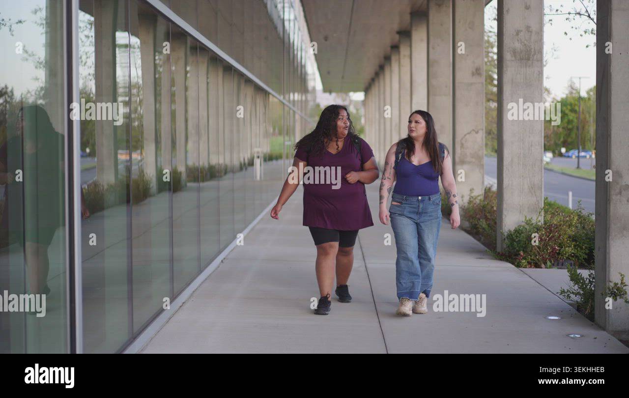 Two female students walking and talking together on campus Stock Video ...