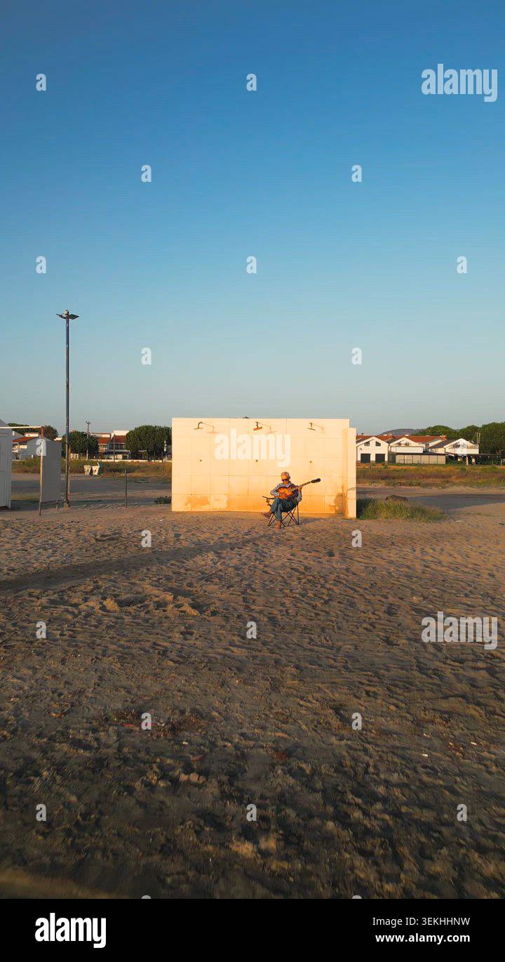 Senior man playing guitar on the beach as drone camera approaches Stock ...