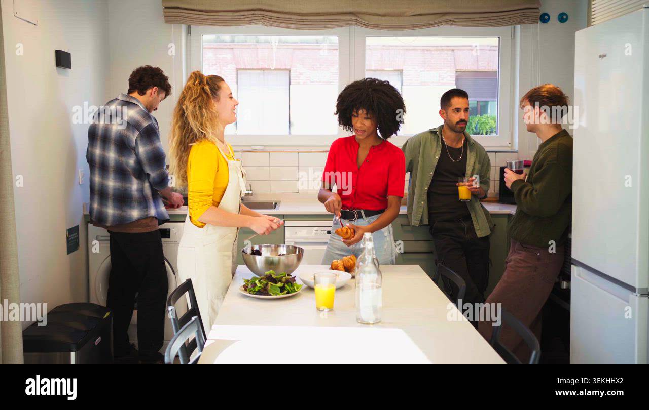Diverse friends cooking and preparing breakfast in shared kitchen Stock ...