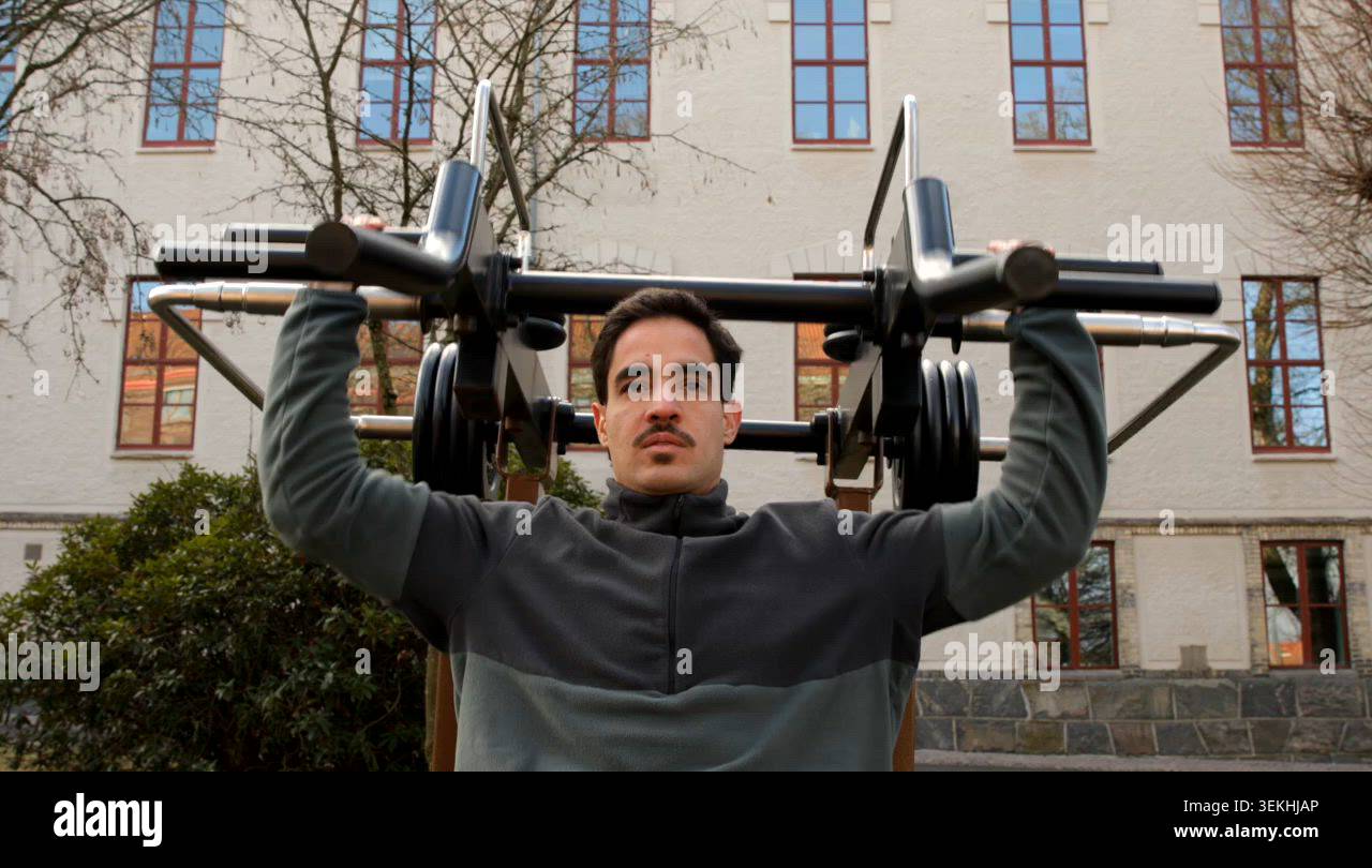 Man Performing Shoulder Press on Resistance Machine at Outdoor Gym ...