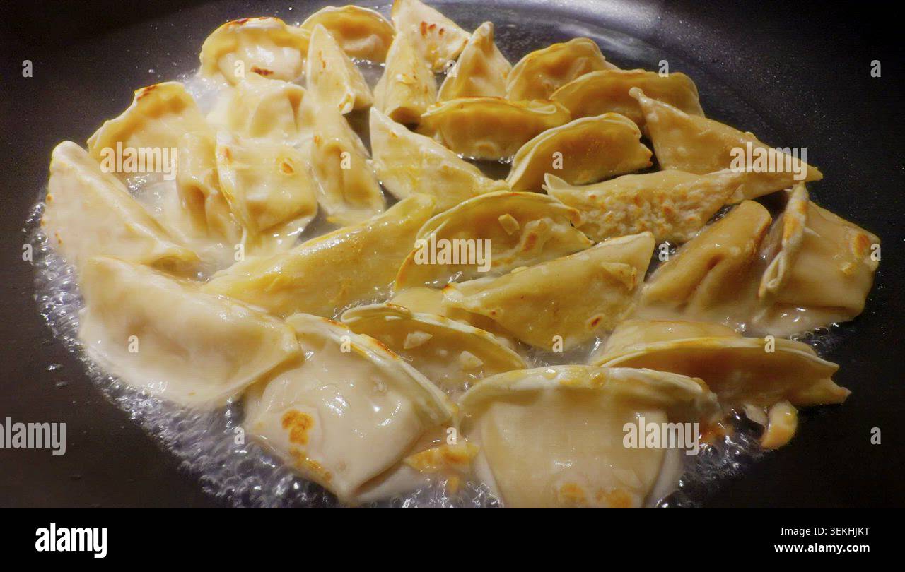 Cooking Dumplings in a frying pan Stock Video Footage - Alamy