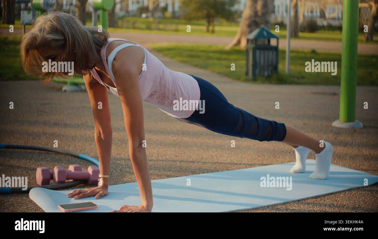 A woman doing a plank exercise in the park Stock Video Footage - Alamy